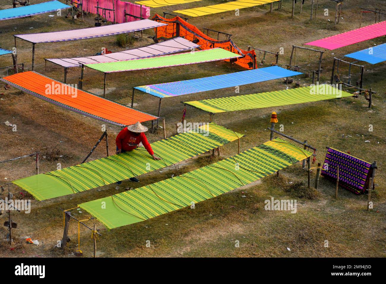 A view of colourful Indian sarees drying under sun. The saree is a traditional form of dress for ...