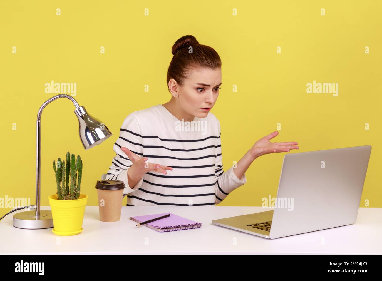 Young woman office worker raising hands in indignant gesture, asking ...