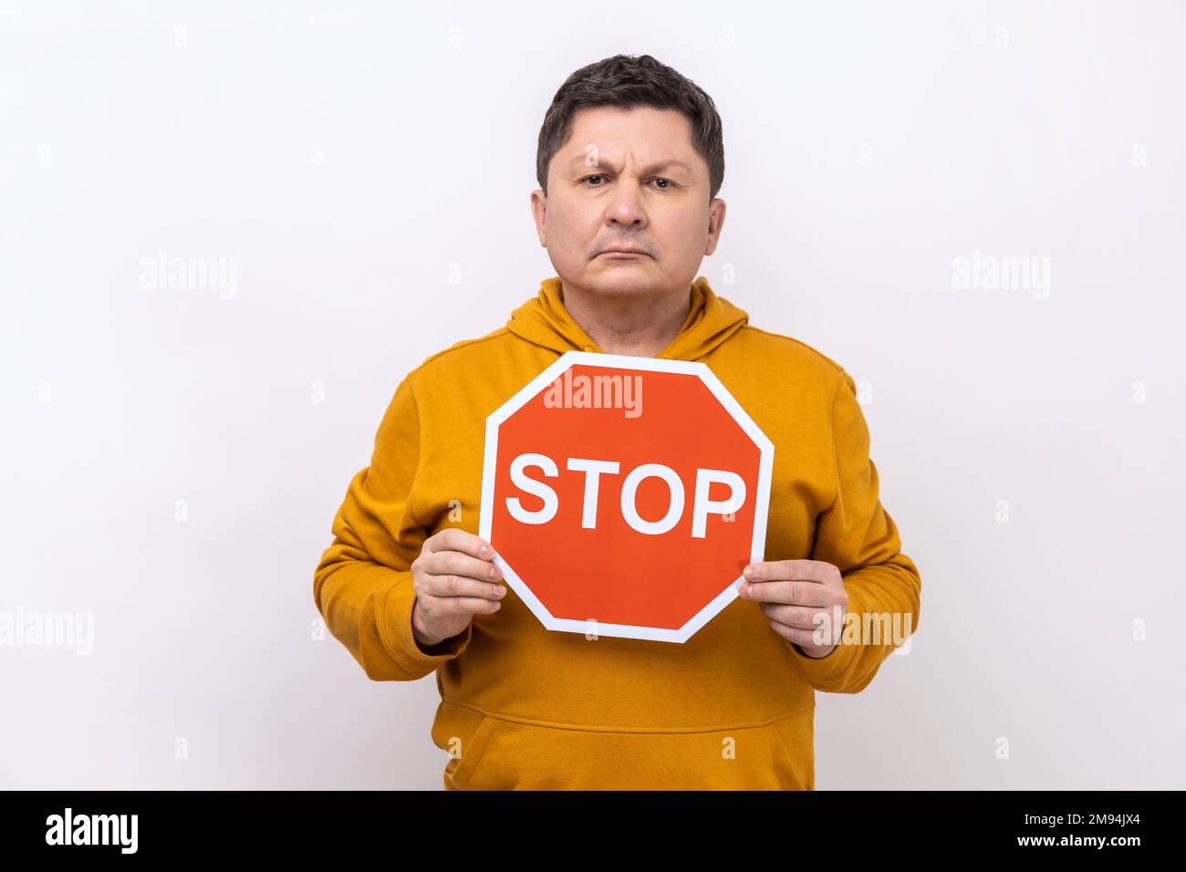 Portrait of middle aged serious self confident holding stop sign ...