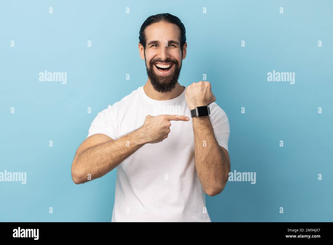 Look at clock, no rush. Portrait of man with beard wearing white T ...