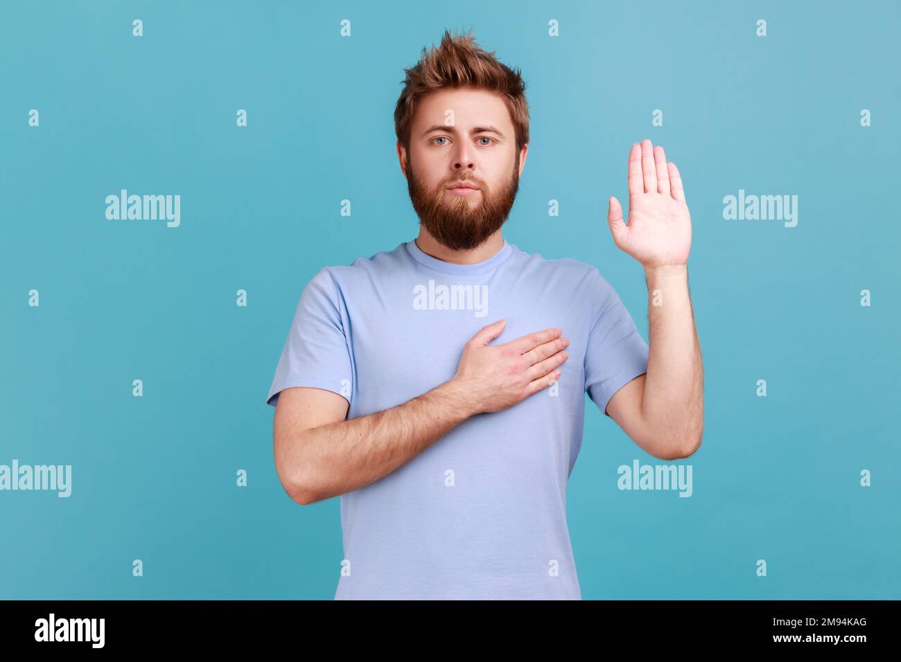 Portrait of honest sincere bearded man giving promise with hand on ...