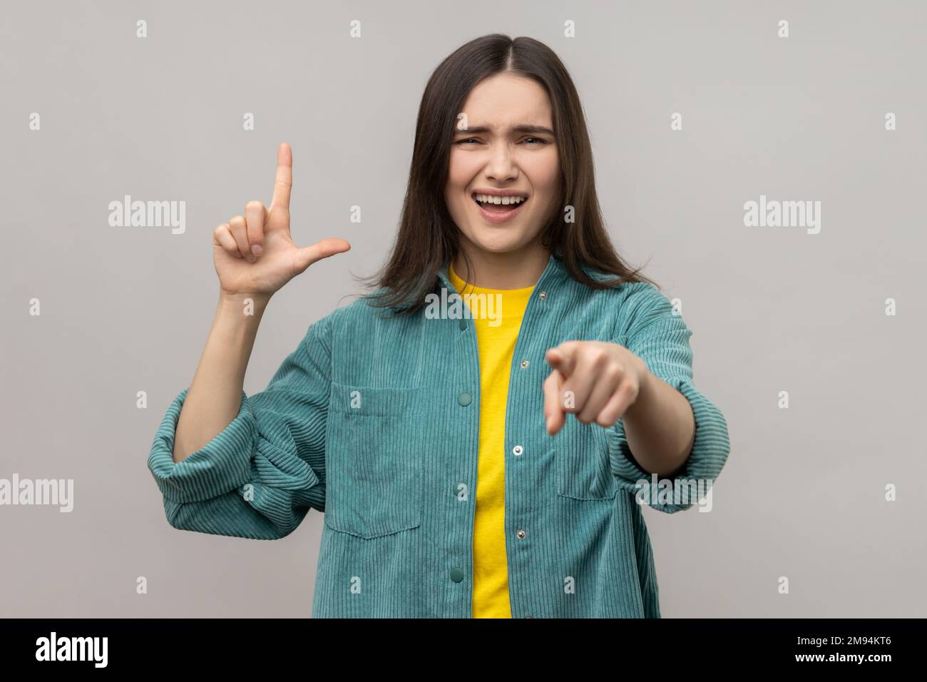 Disrespectful rude young woman showing loser gesture and pointing on ...