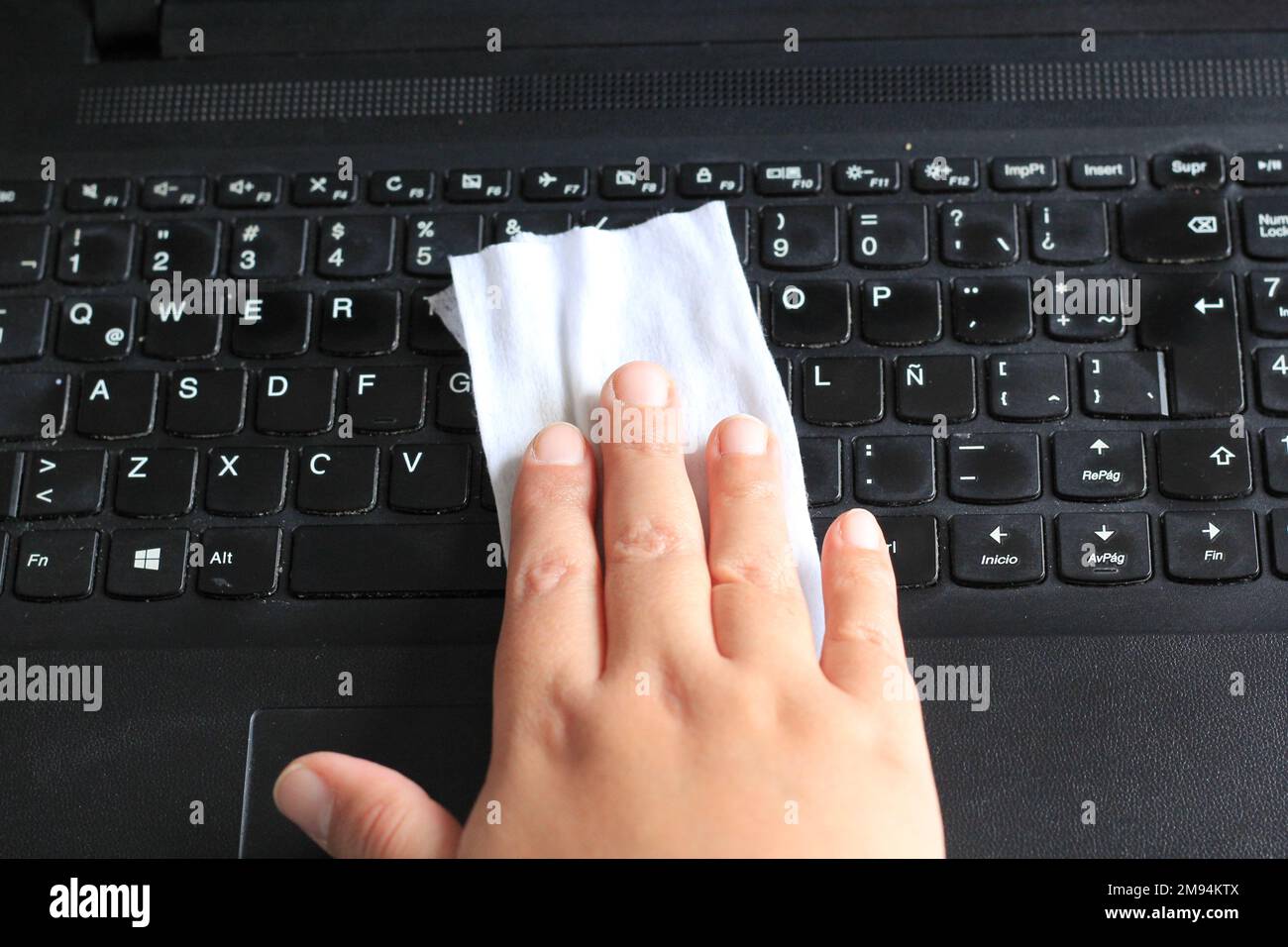 Clean computer keyboard with antibacterial wet towel, virus prevention ...