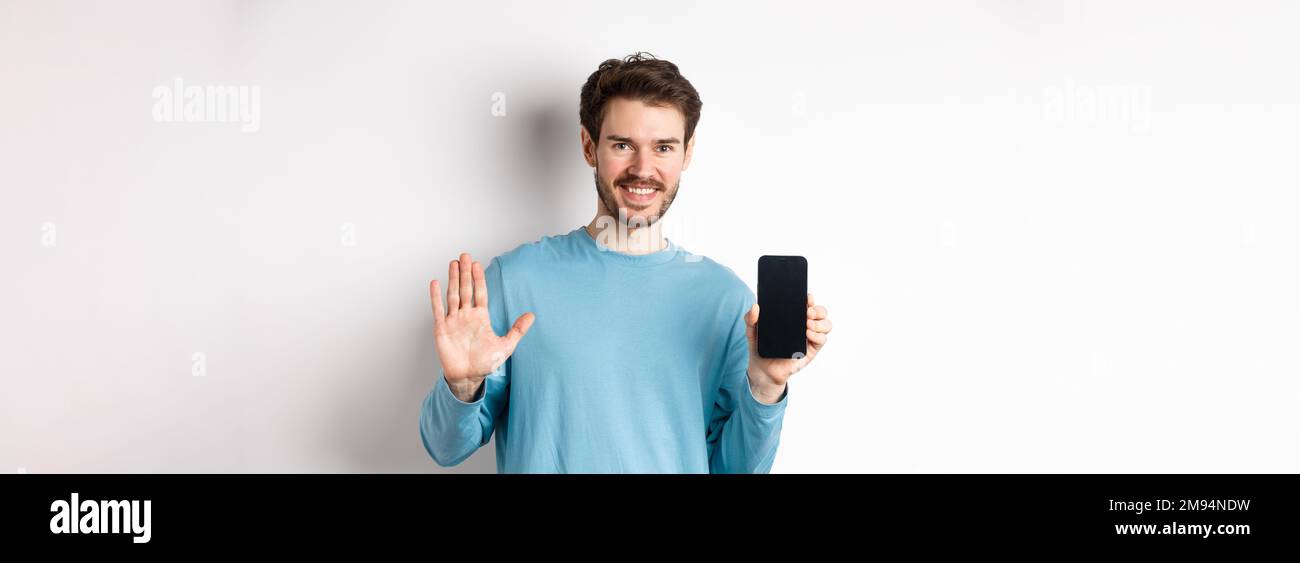 Handsome caucasian man with beard, showing empty smartphone screen and ...