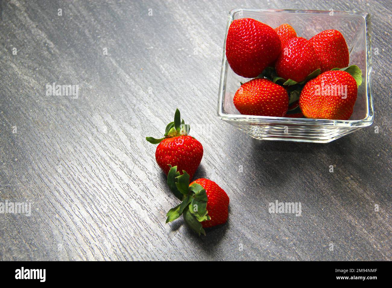 Fruit red strawberries in glass bowl on a vintage gray wood background ...