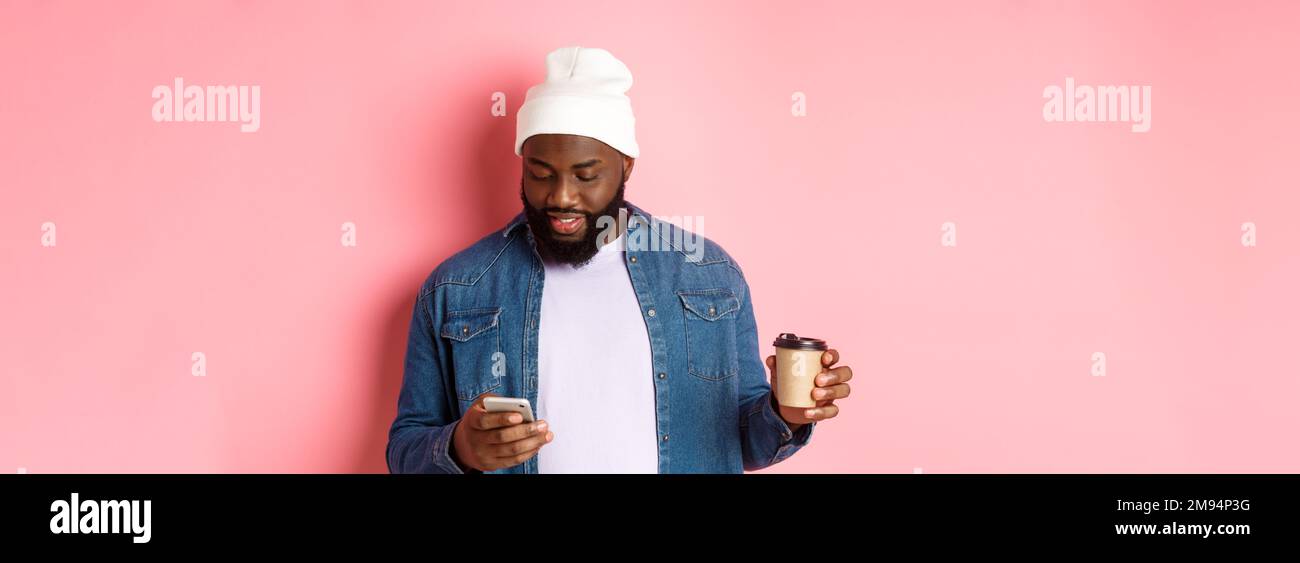 Image of stylish Black man hipster drinking takeaway coffee, reading ...