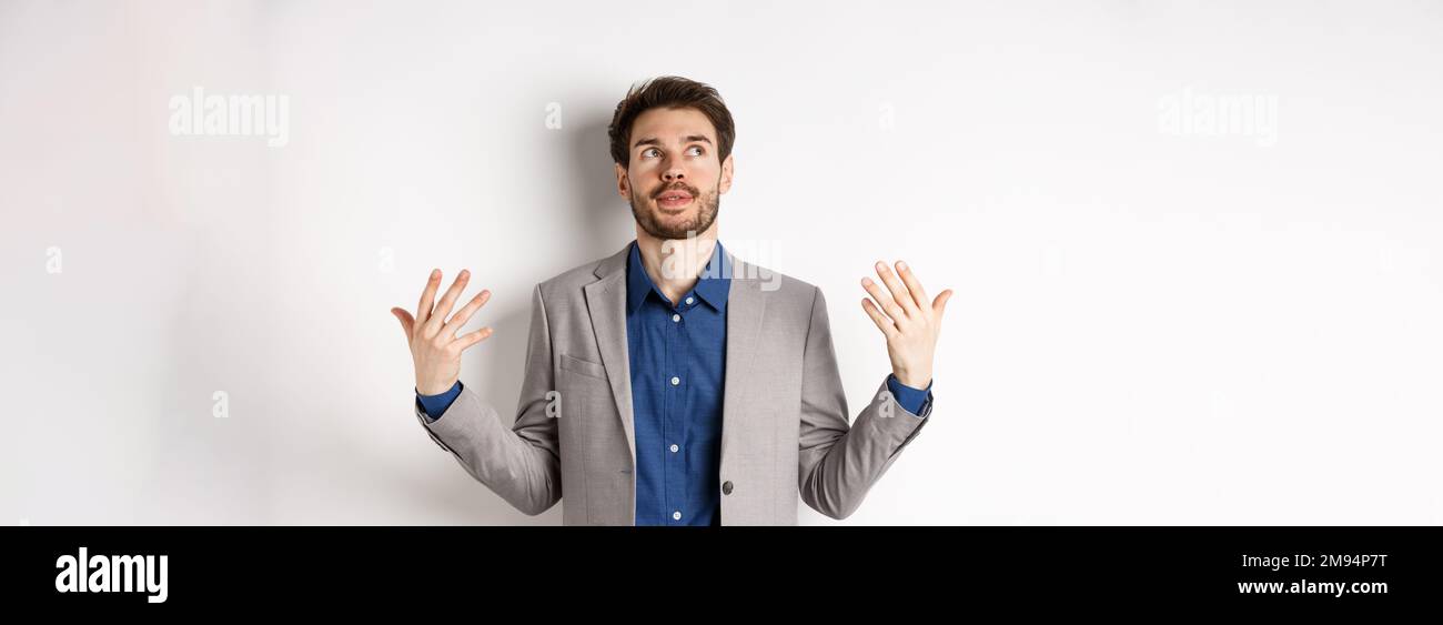 Tensed young manager in suit need some air, waving at himself as ...