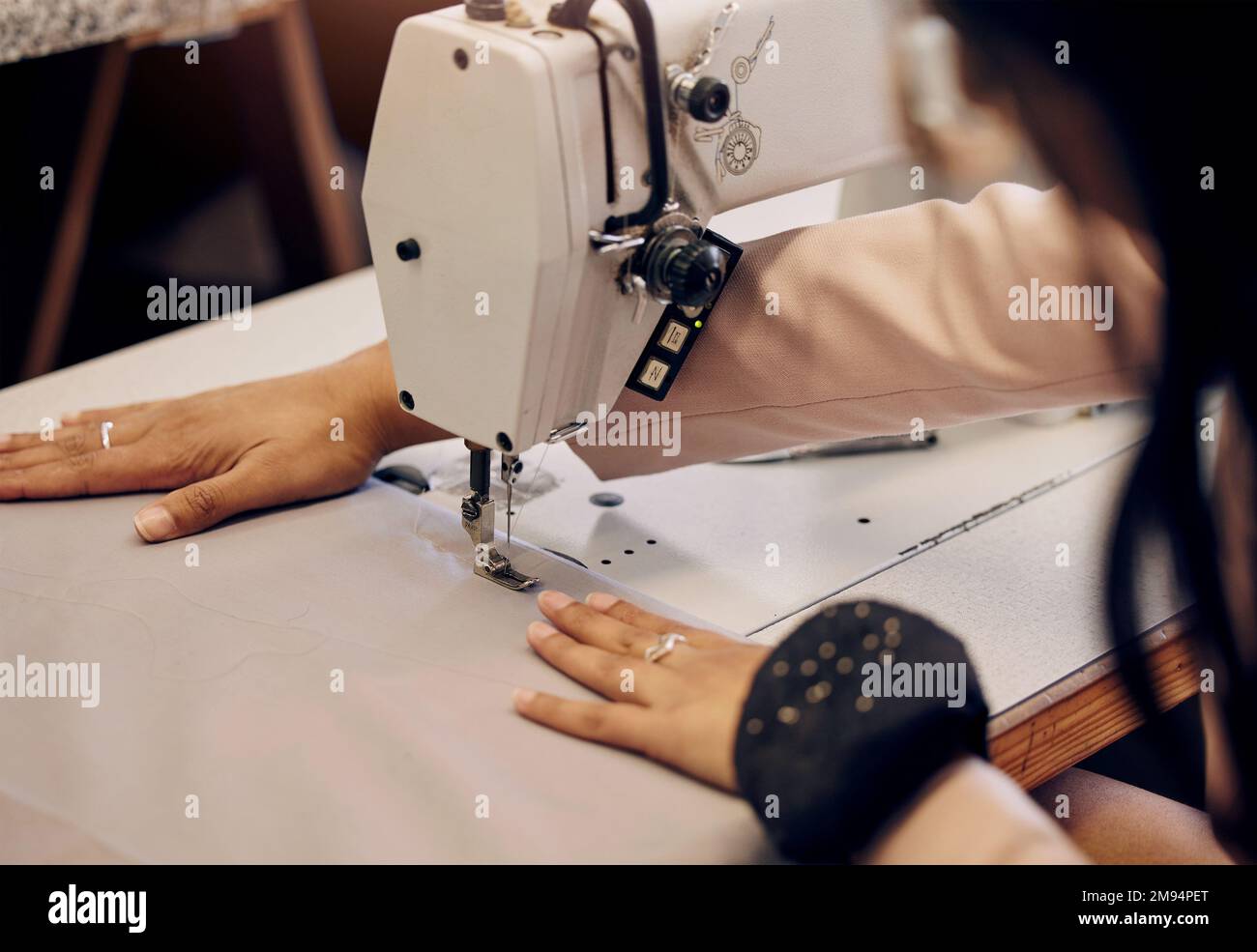Custom made just for you. a seamstress using a sewing machine while ...