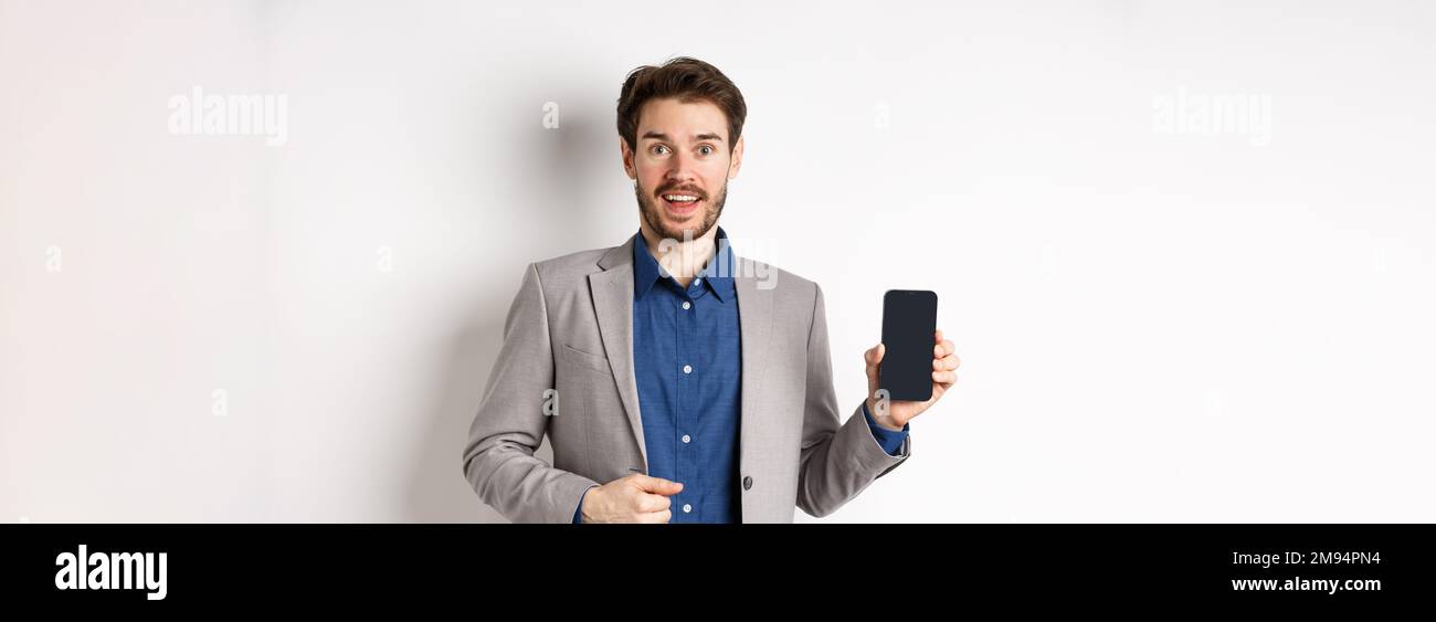 Excited businessman ceo in suit showing empty phone screen and smiling ...