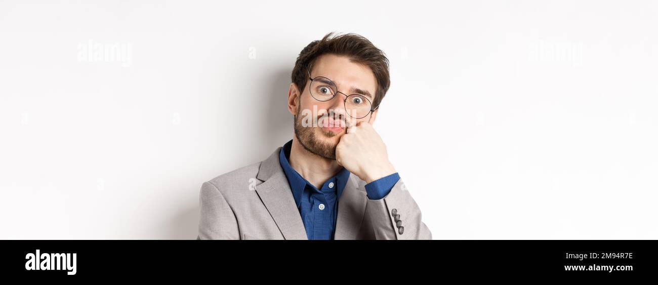 Bored funny office worker in glasses, pouting and holding breath ...