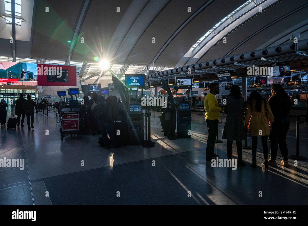 People line up to check in at the Air Canada counter at the YYZ Toronto ...
