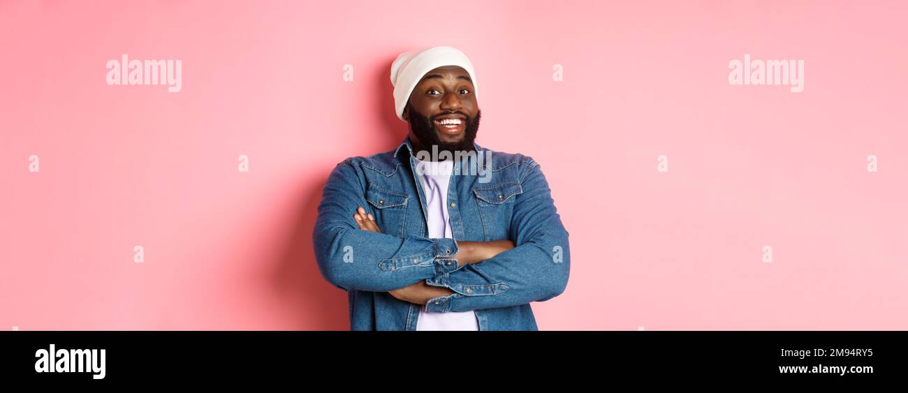 Happy Black man with beard, wearing beanie and denim shirt, looking ...
