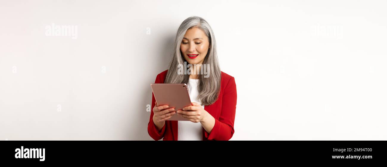 Business. Successful senior businesswoman working with digital tablet ...