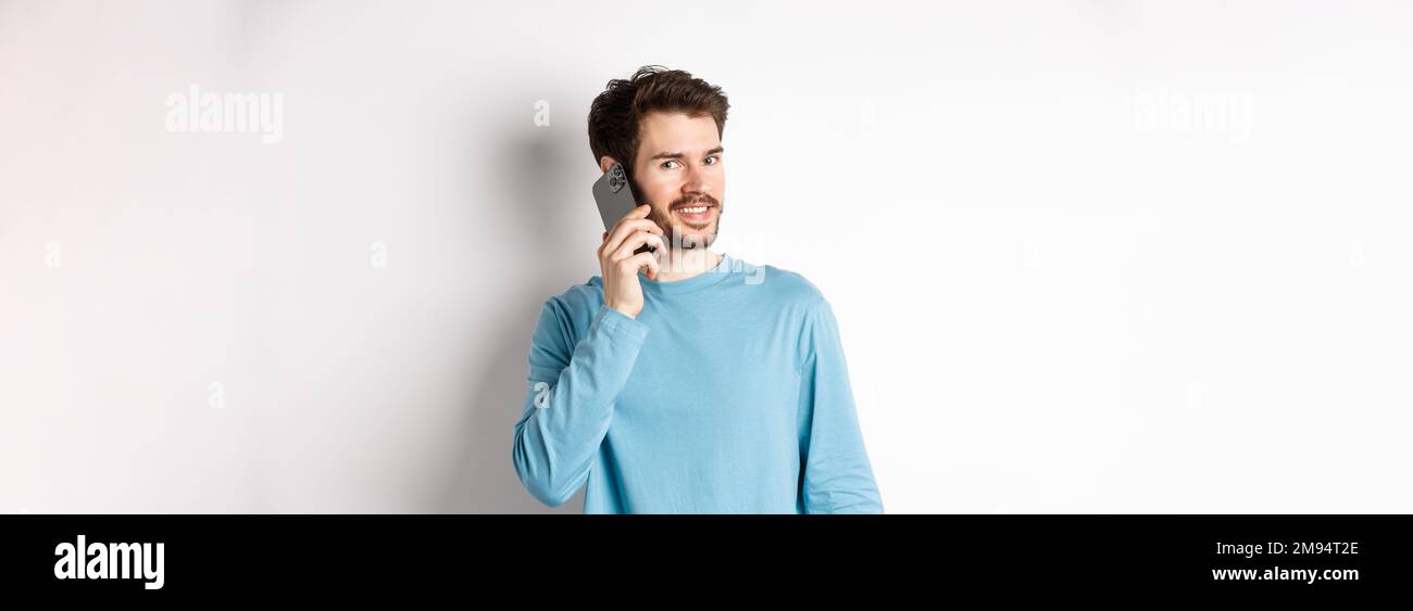 Technology concept. Young male model talking on mobile phone, calling ...