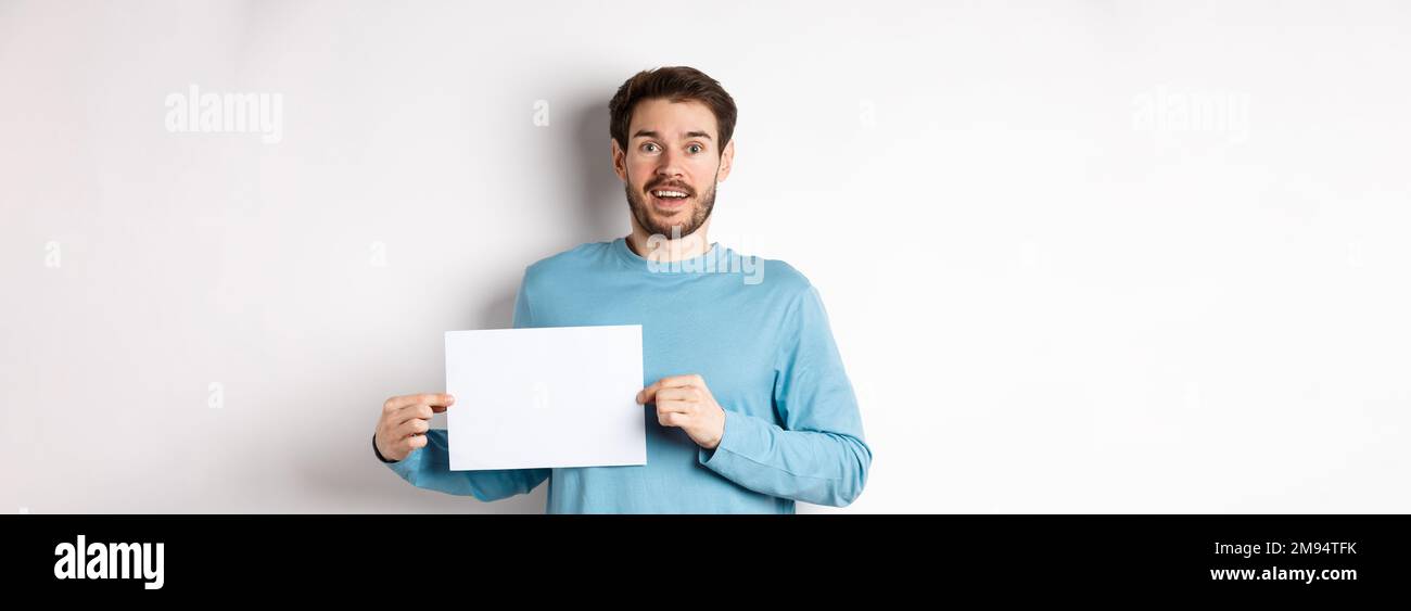 Romantic man looking with hopeful face at camera, showing sign card ...