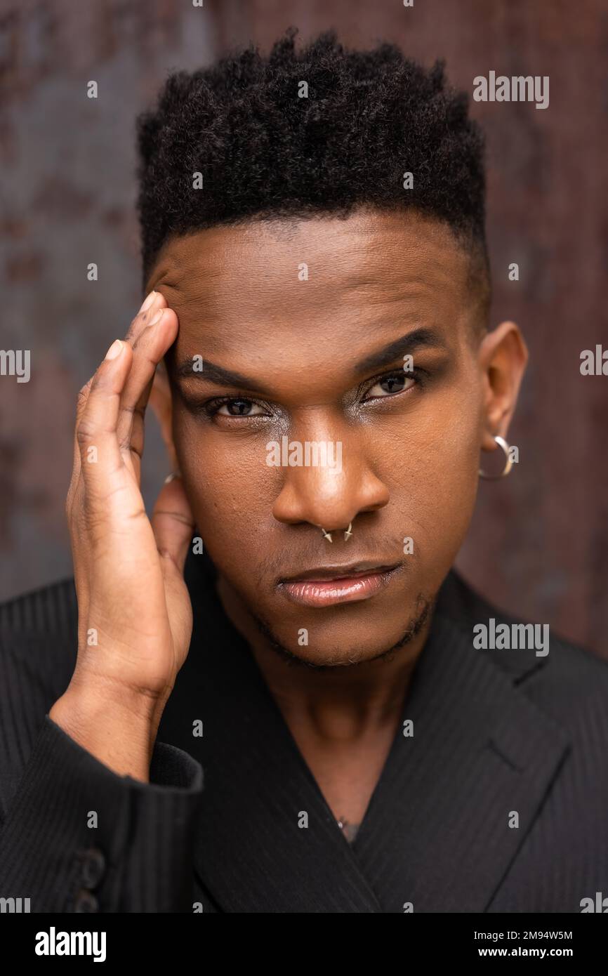Portrait of a black ethnic man in a fashion pose on a metallic ...