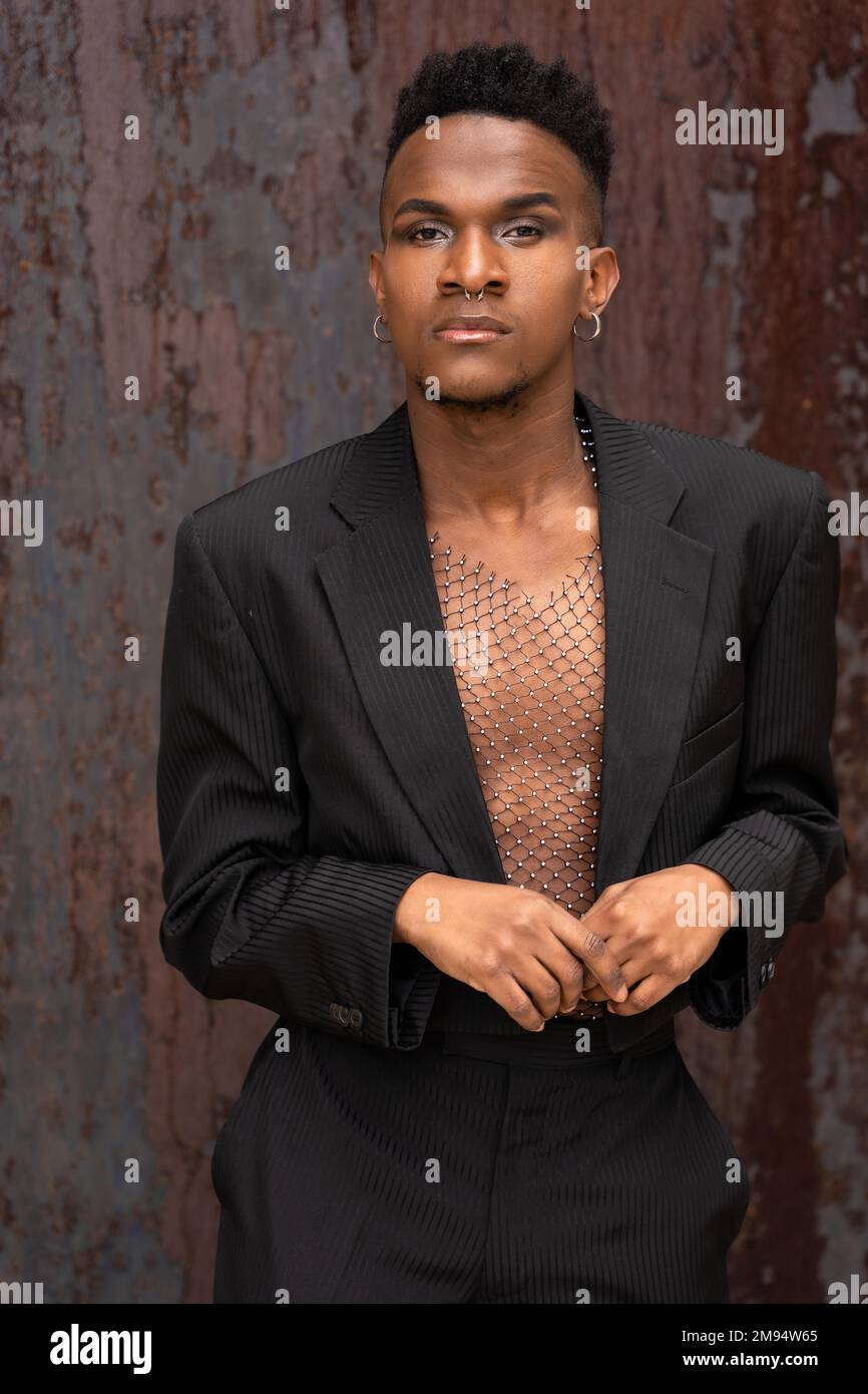 Black ethnic man in a fashion pose on a metallic background with rust ...