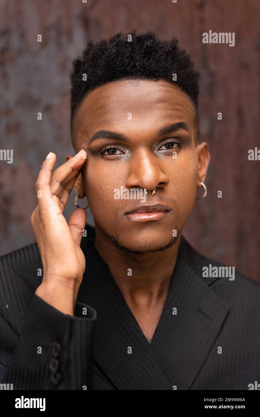 Portrait of a black ethnic man in a fashion pose on a metallic ...