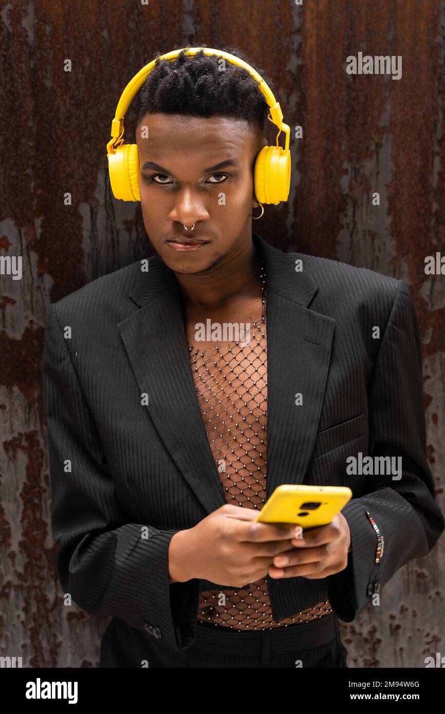 A man of black ethnicity listening to music wireless yellow headphones ...