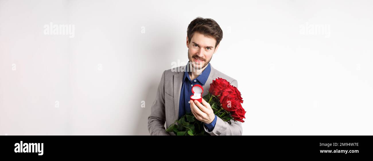 Romantic man with boquet of red roses asking to marry him, holding ...