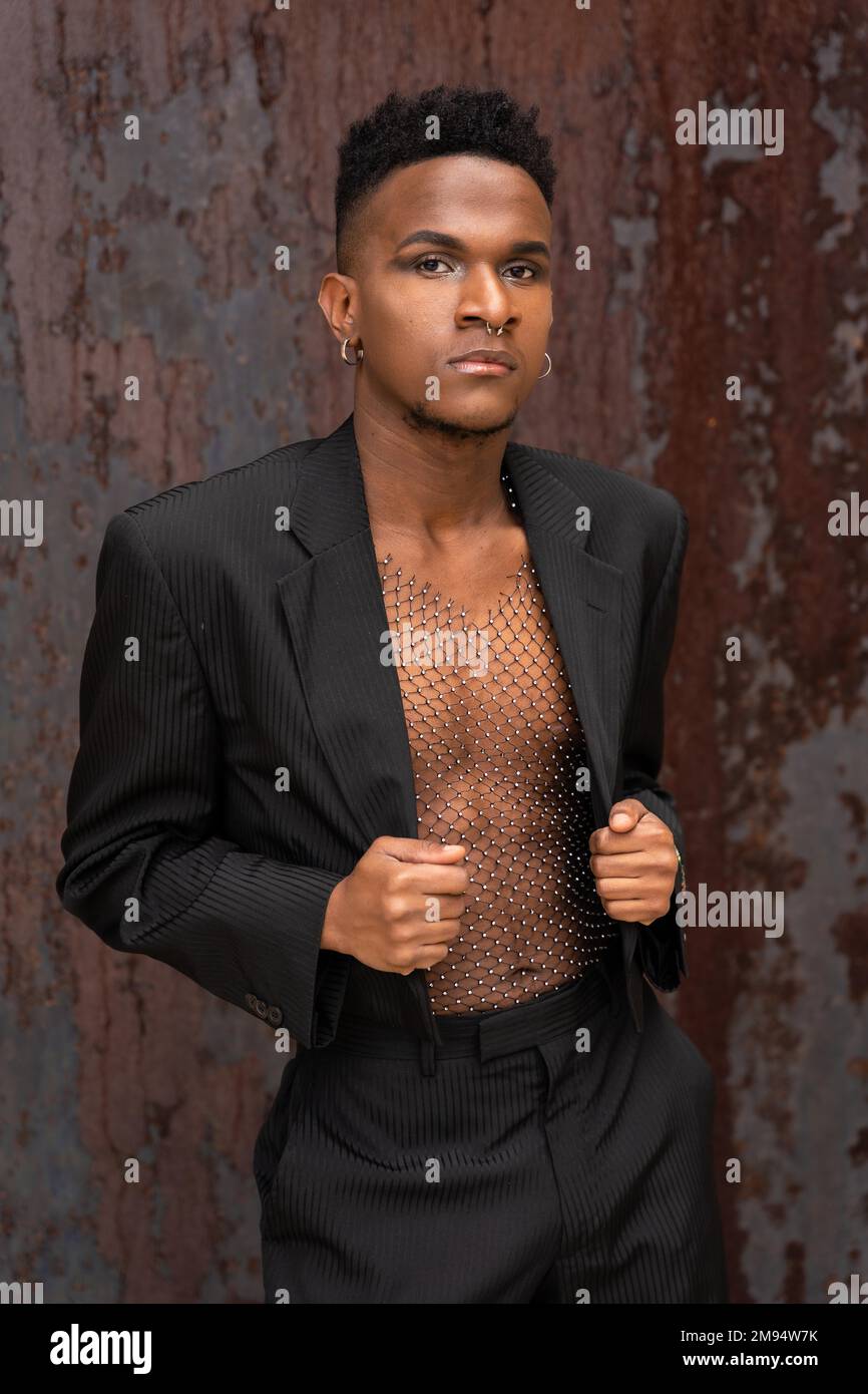 Black ethnic man in a fashion pose on a metallic background with rust ...