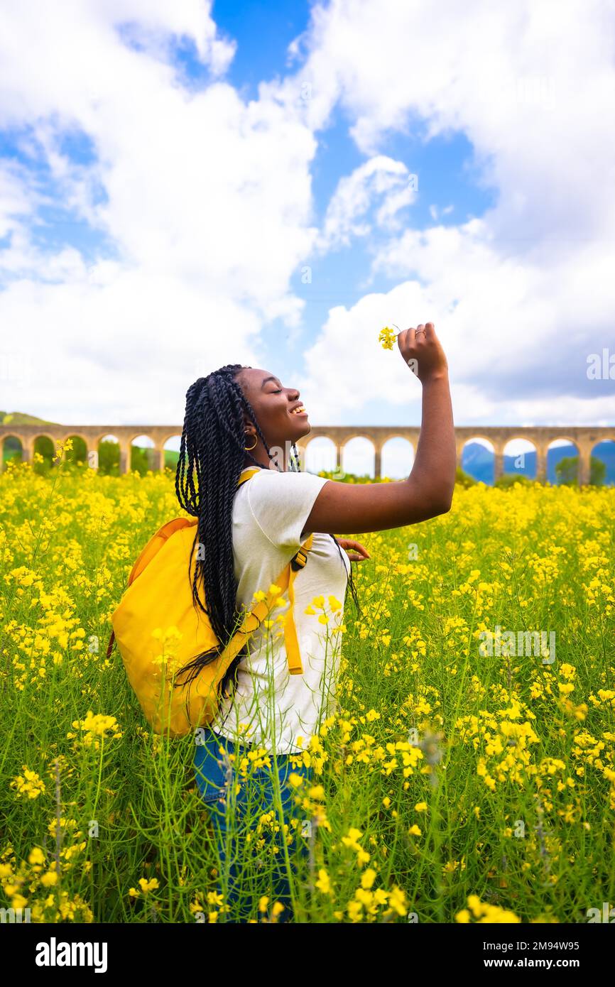 Breathing fresh air and the scent of the flower, a black ethnic girl ...