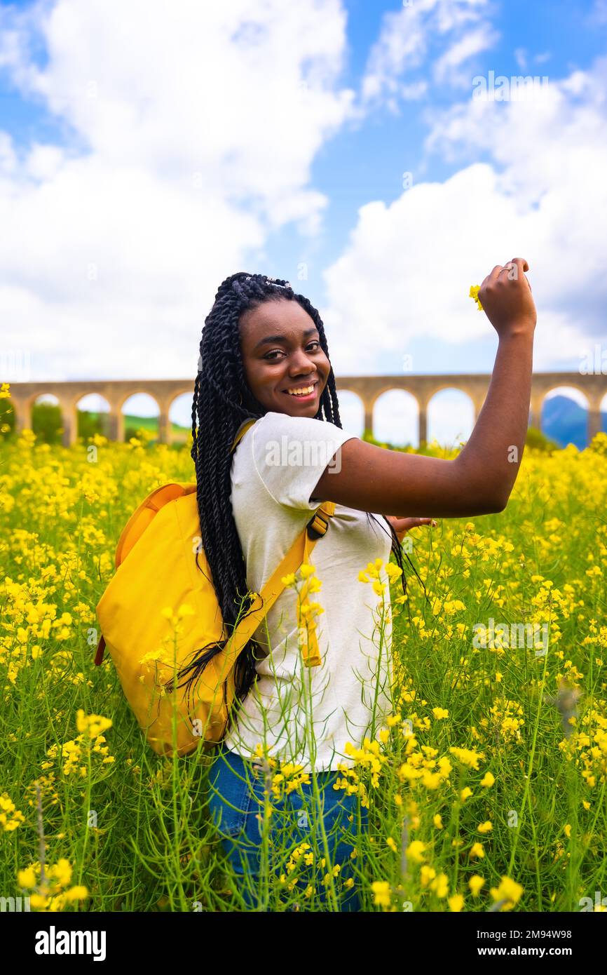 Breathing fresh air and the scent of the flower, a black ethnic girl ...