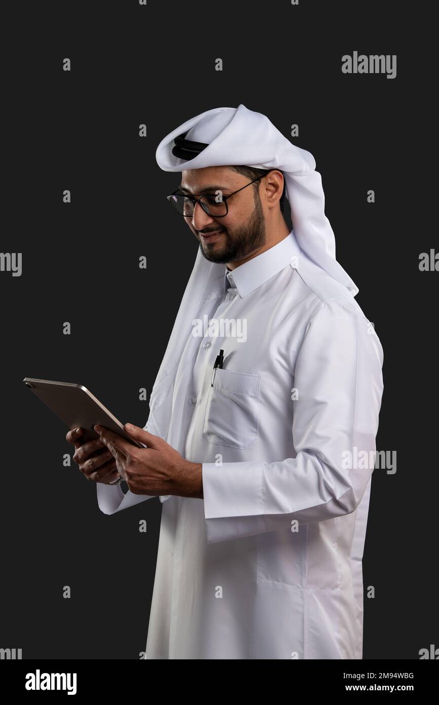 Arab Qatari Man using tablate and posing on isolated background. Male ...