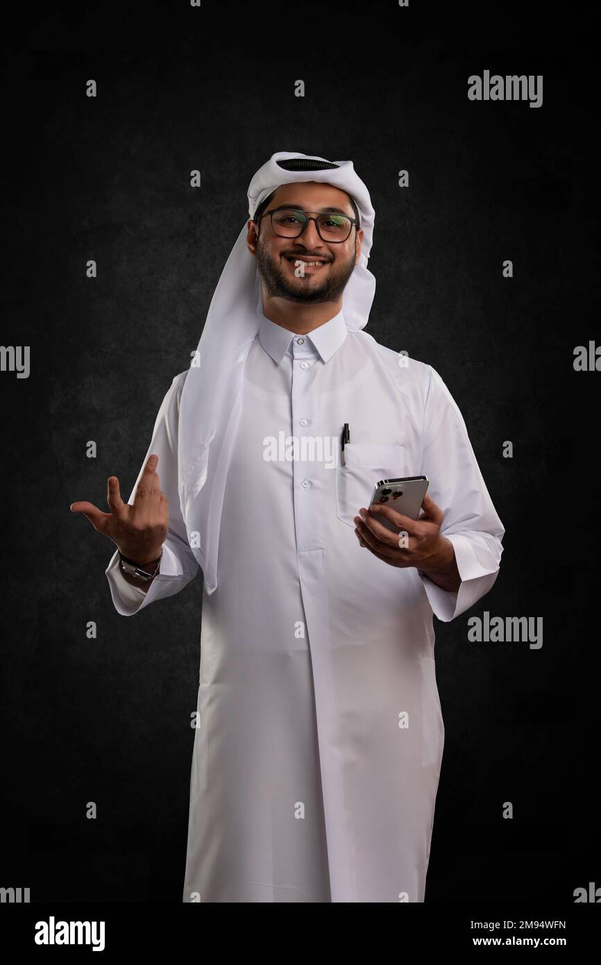 Arab Qatari Man using tablate and posing on isolated background. Male ...