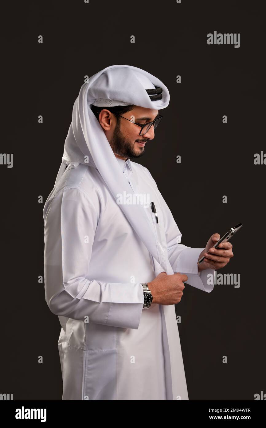 Arab Qatari Man using tablate and posing on isolated background. Male ...