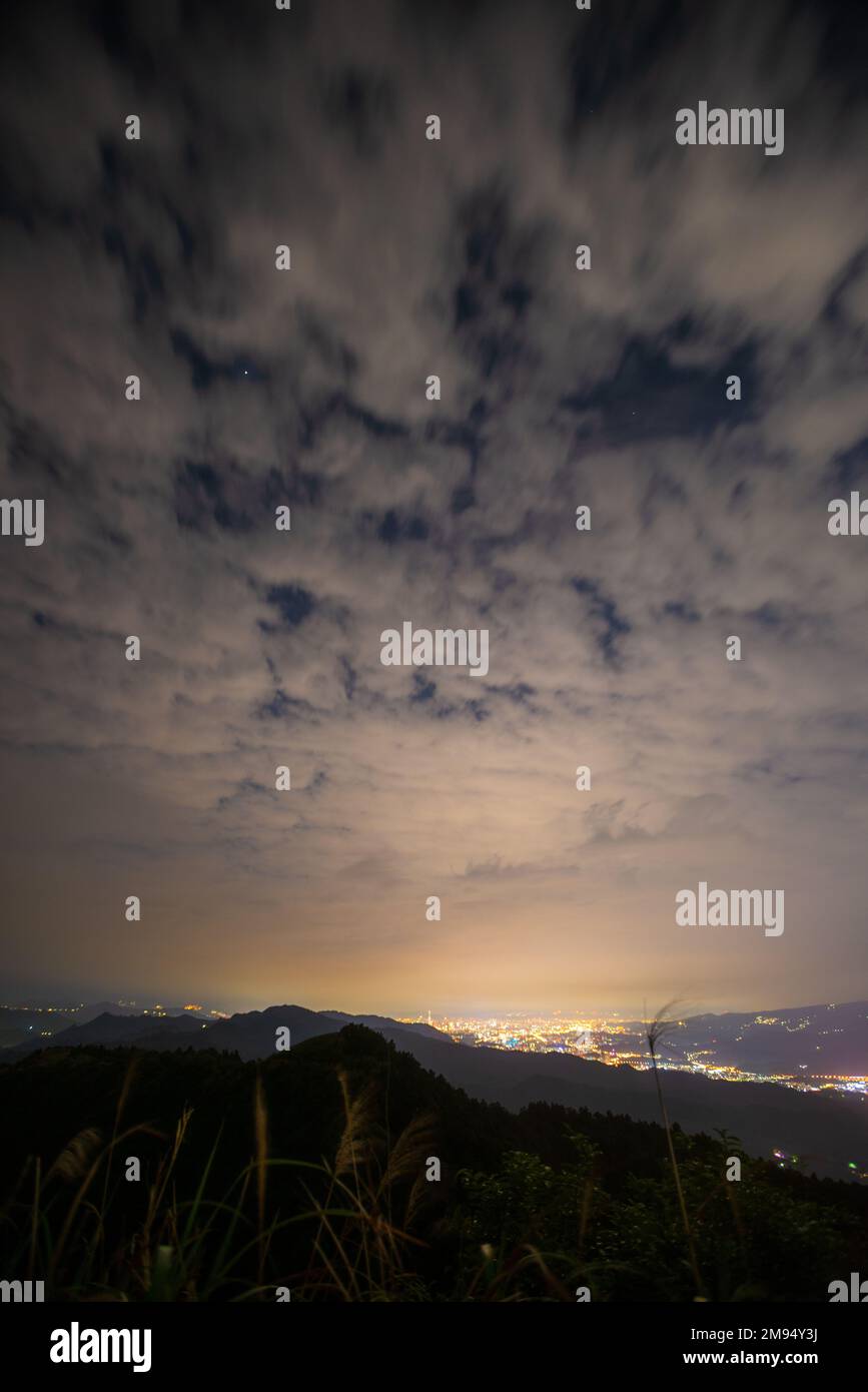 Clouds moving in the sky at night. Neon lights shine on the vibrant ...