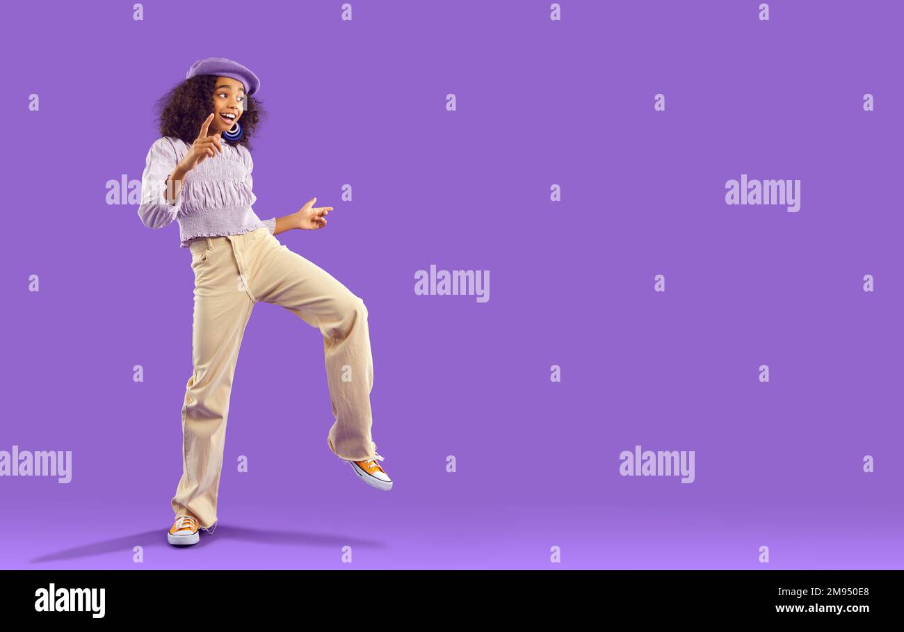 Smiling teen girl dancing on violet background Stock Photo - Alamy