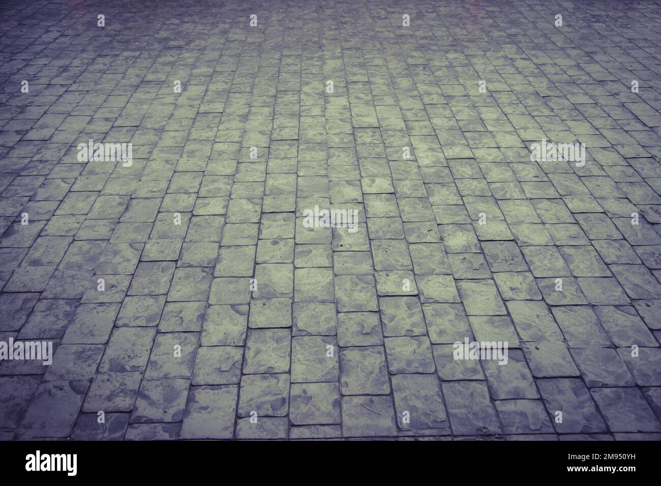 Road made of small pieces of old gray bright stone use for background ...