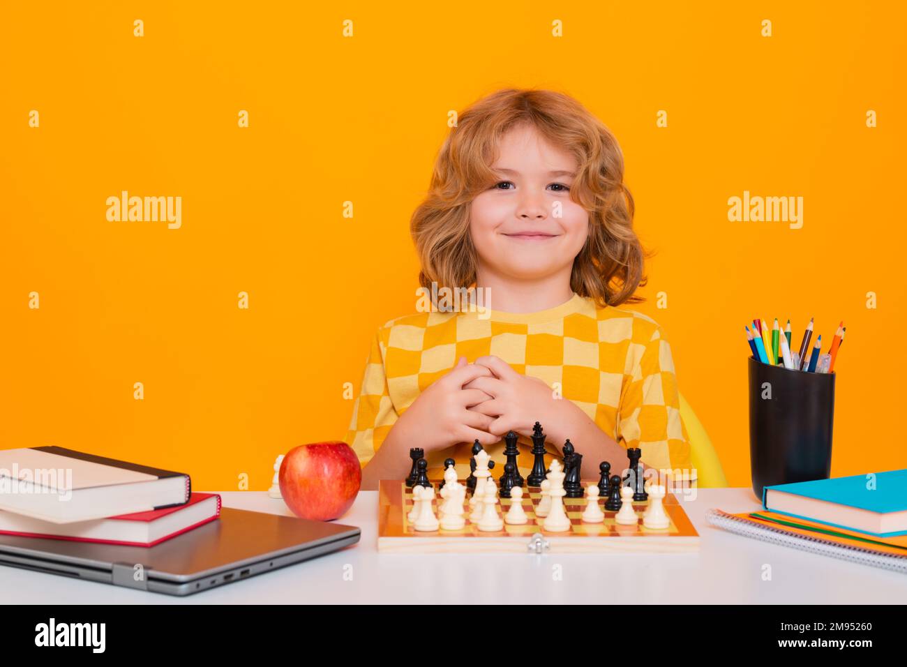 Child play chess on studio background. Clever concentrated and thinking ...