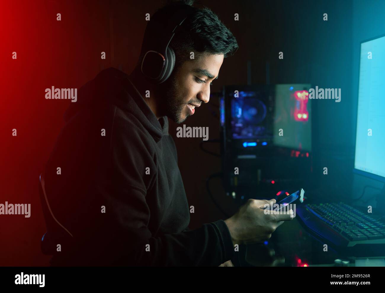 We jamming. a handsome young male gamer playing video games in a dark ...