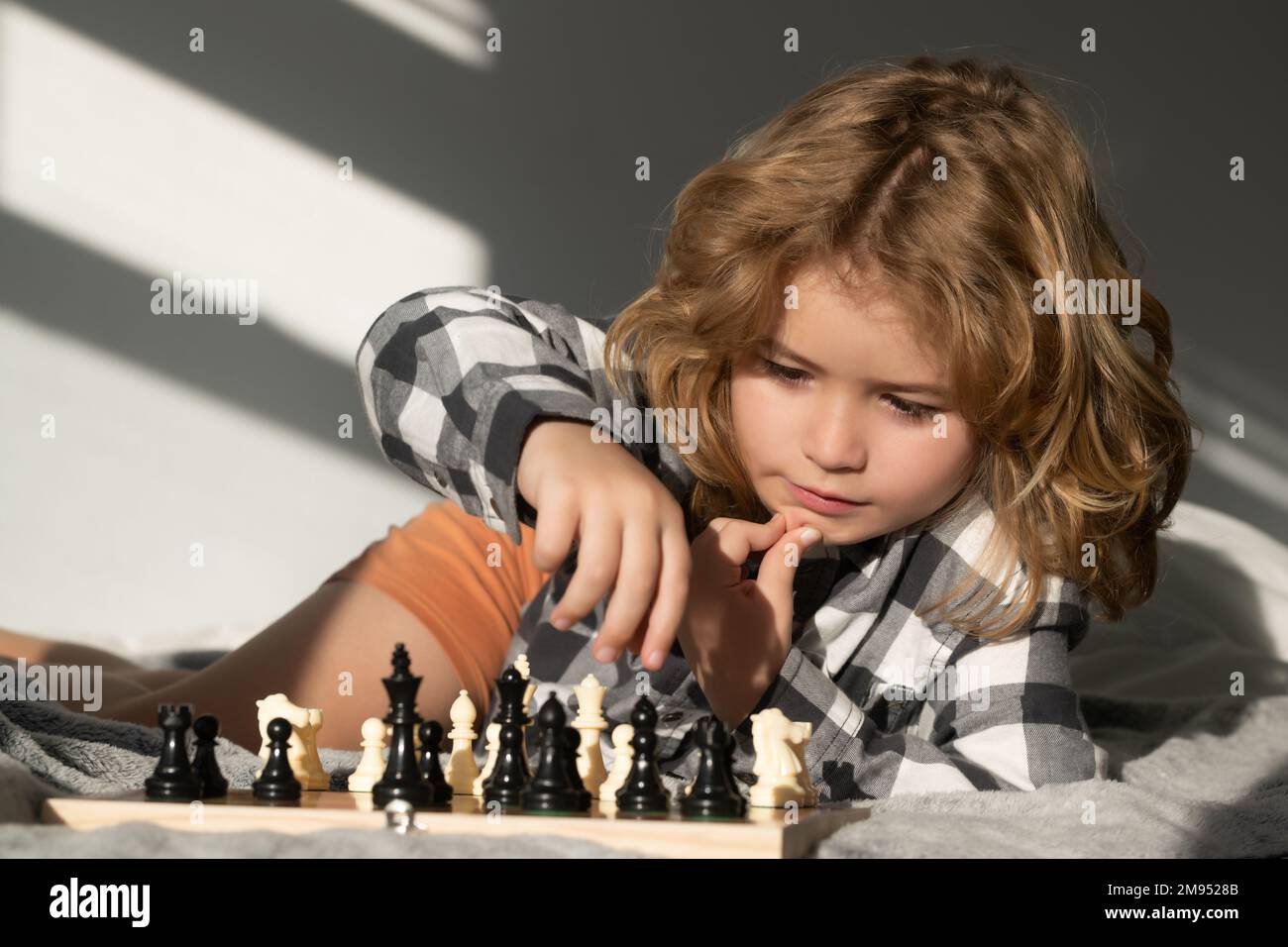 Chess game with kids at home. Chess for intelligent kid. Child genius, smart pupil playing logic ...