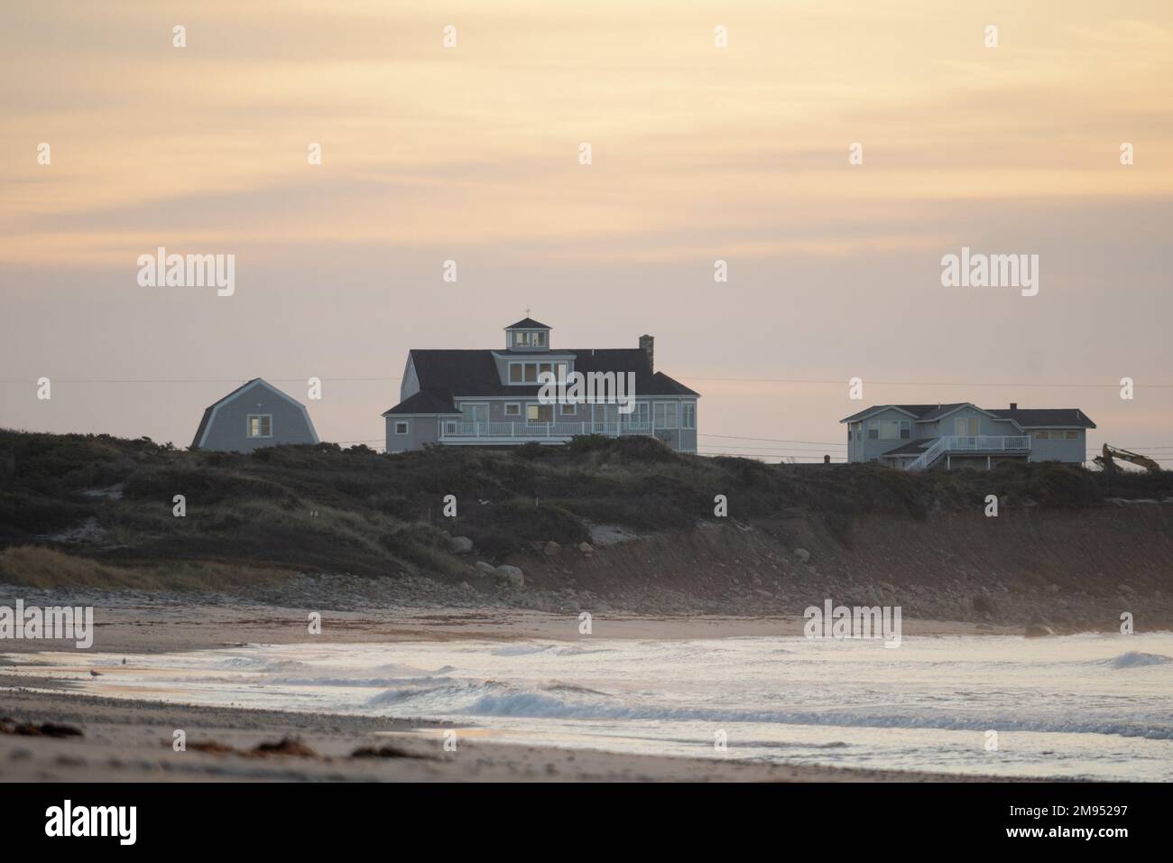 An aerial view of beach with buildings in Little Compton during sunset ...