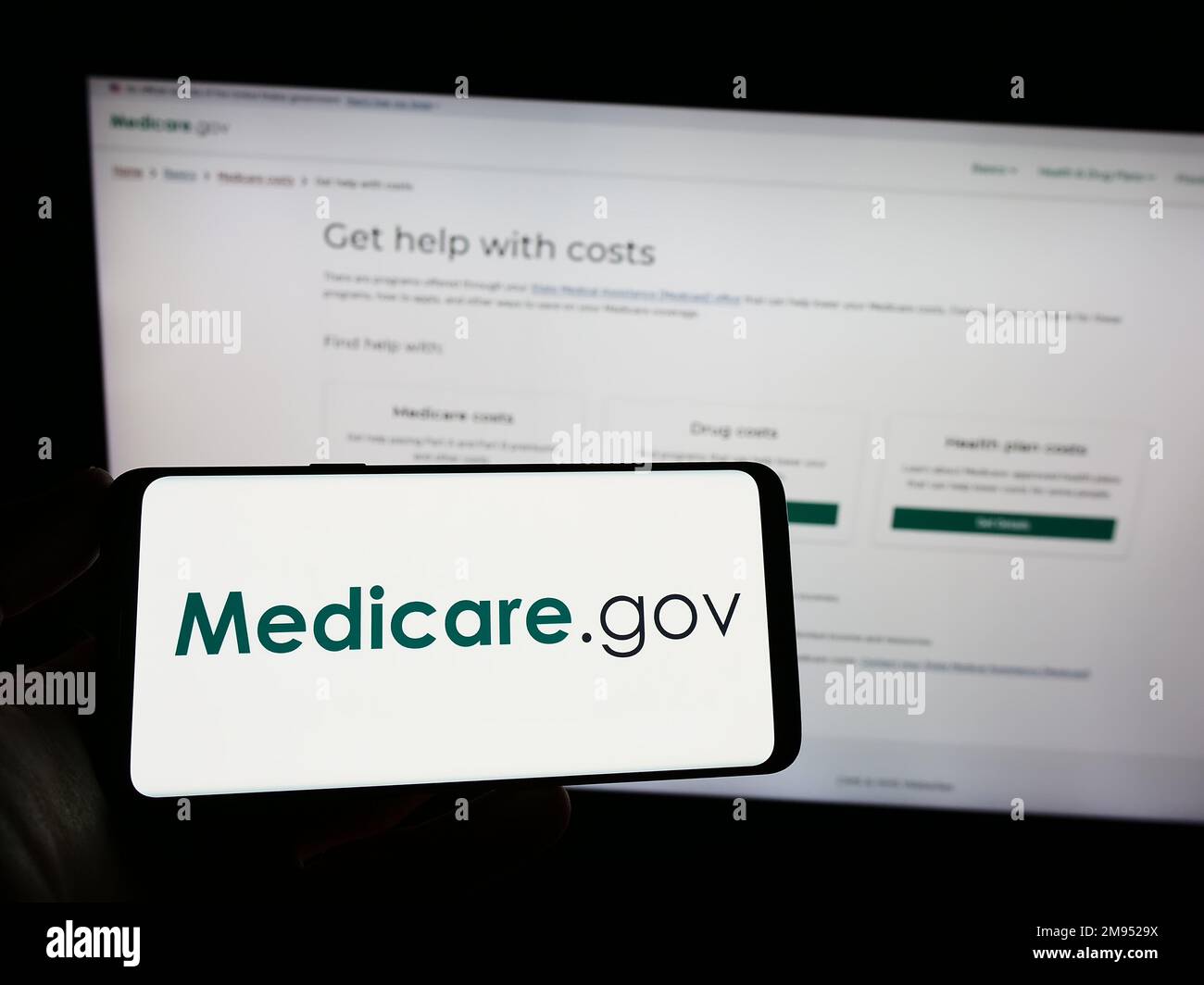 Person holding smartphone with logo of US health insurance program ...