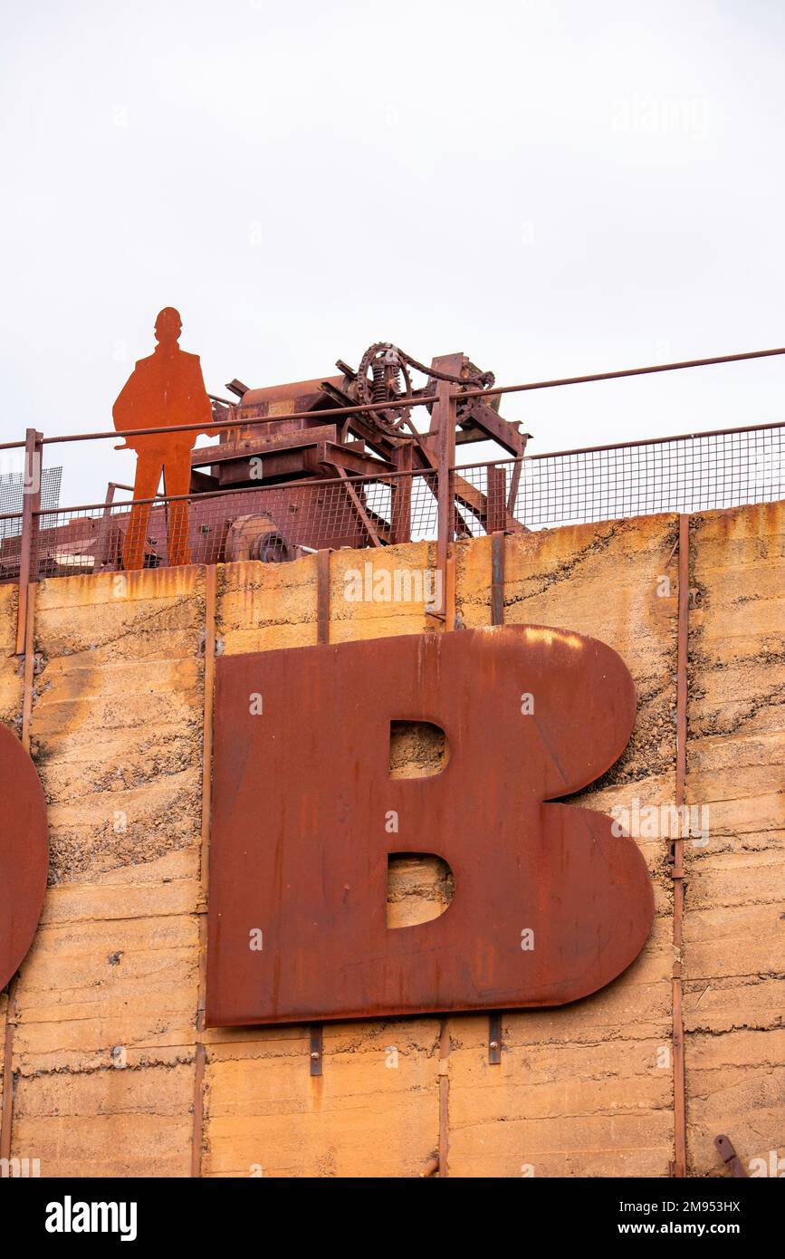 A close-up of the large COBAR sign and a silhouetted iron mining figure ...