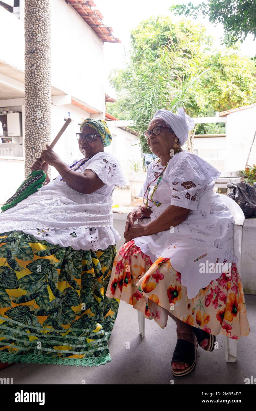 A view of Candomble members sitting in traditional clothes waiting for ...