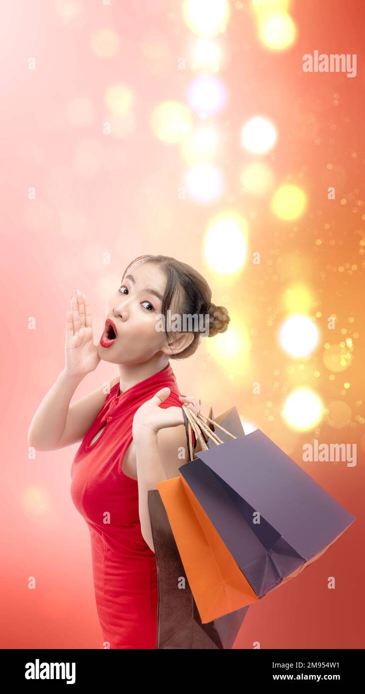 Asian Chinese woman in a cheongsam dress holding shopping bags. Happy ...
