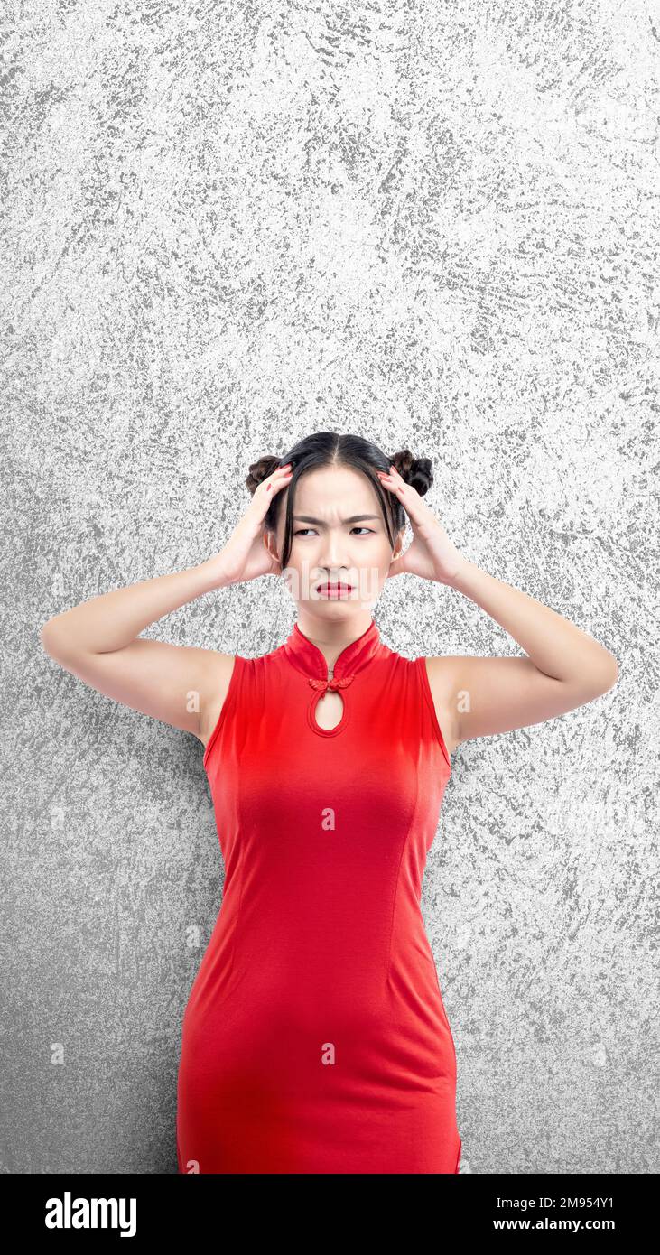 Asian Chinese woman in a cheongsam dress standing with an upset ...