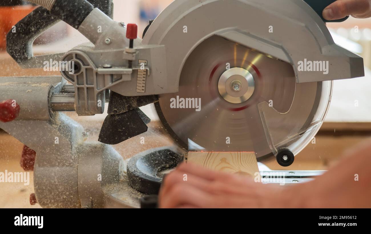 Master cuts the board with a circular saw in the workshop Stock Photo ...
