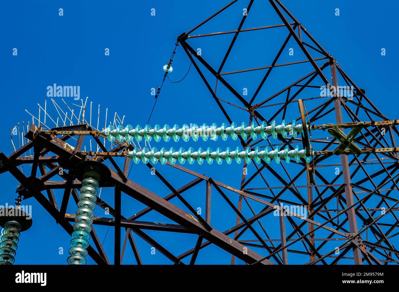 Line insulator on the electrical wires of a high-voltage tower ...