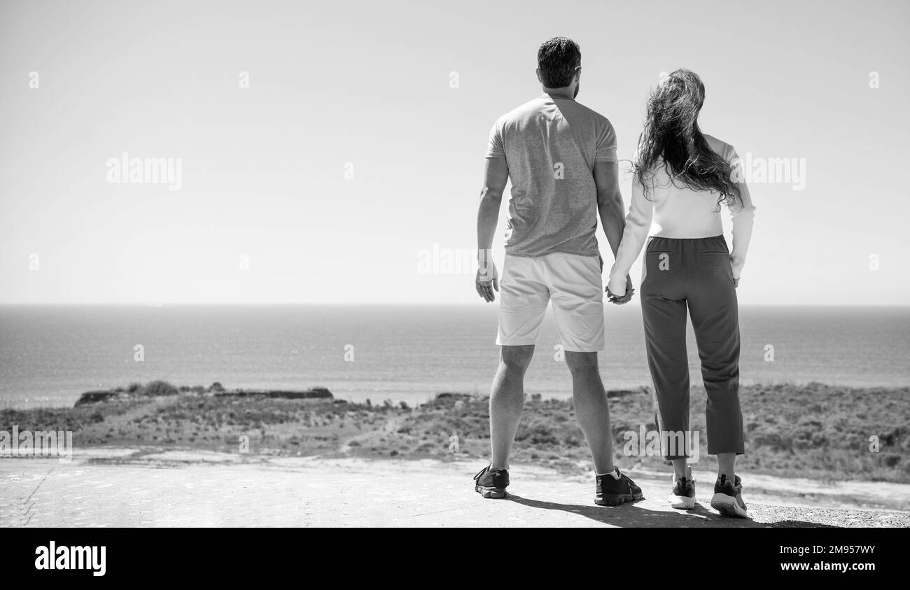 young couple in love holding hands looking at sea from top, future ...