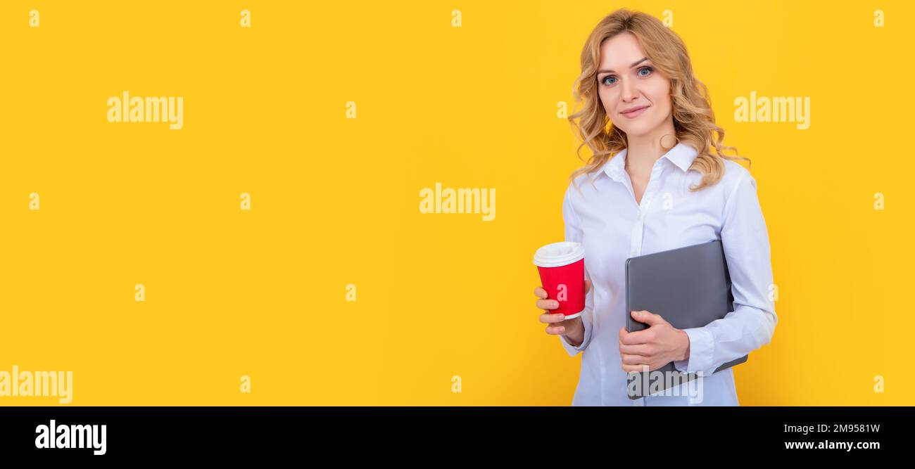smiling blonde woman with coffee cup and computer on yellow background ...