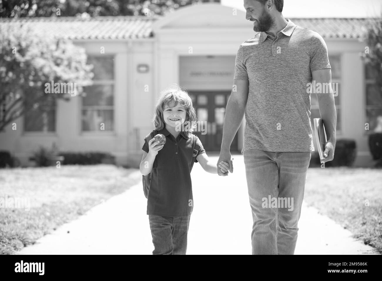 first day at school. father and son come back from school. happy family ...