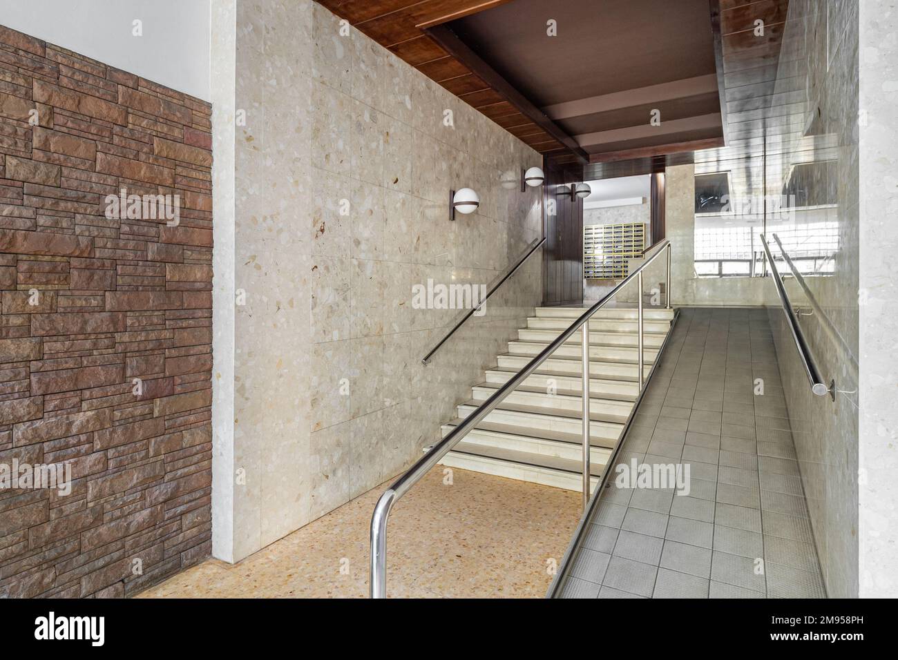Entrance of a house with long corridor, stairs to elevator area with ...