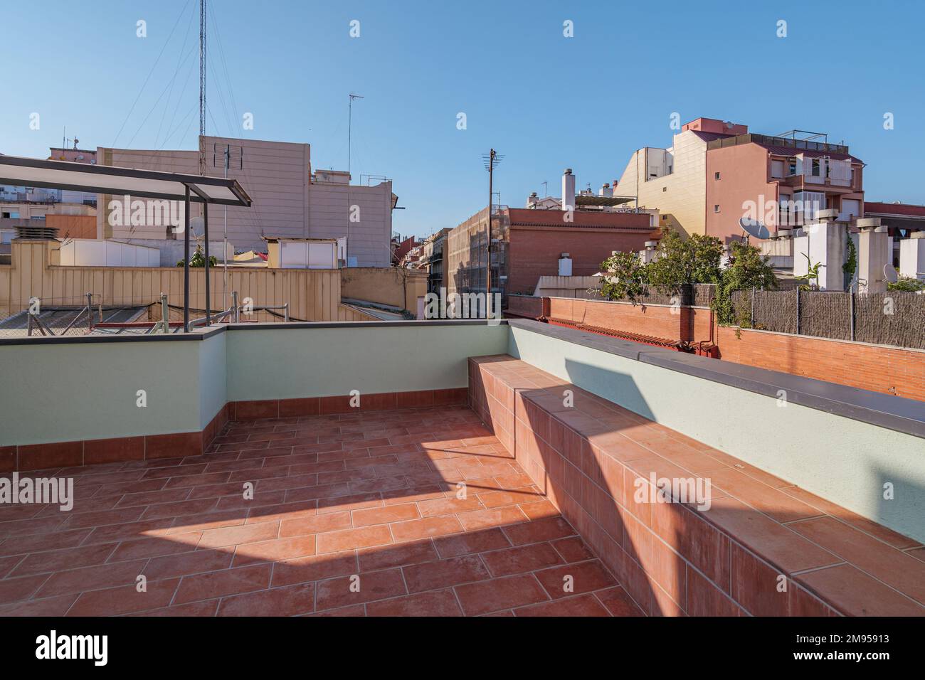 Big sunny terrace on the roof of modern building lined with red brick ...