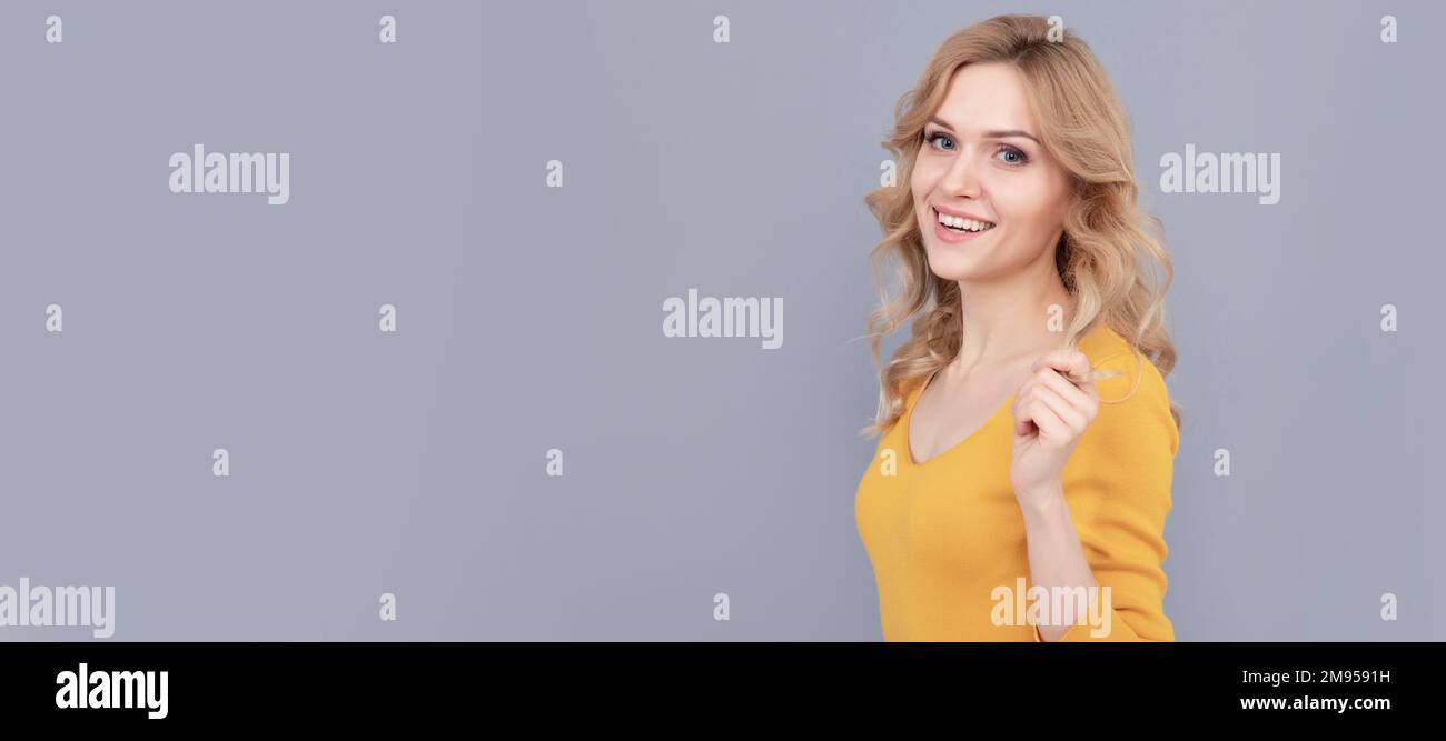 cheerful blonde beauty woman touch curly hair, copy space, hairdresser. Woman isolated face ...